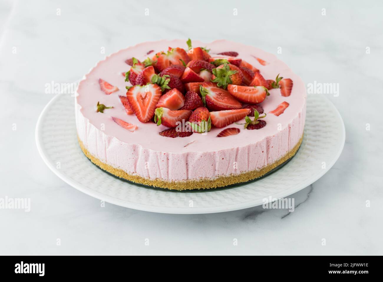 A fresh homemade strawberry cheesecake against a light background Stock ...