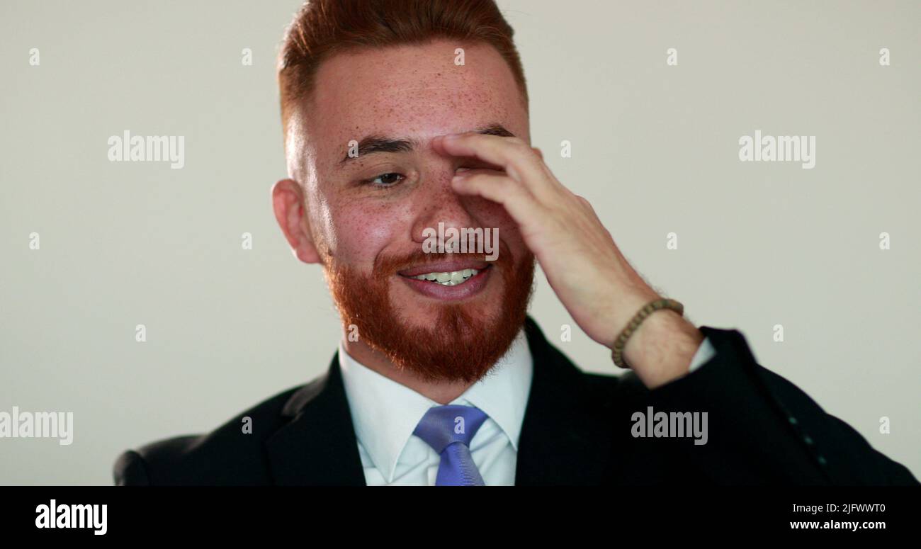 Man rubbing eye with finger smiling, casual reaction. touching face ...