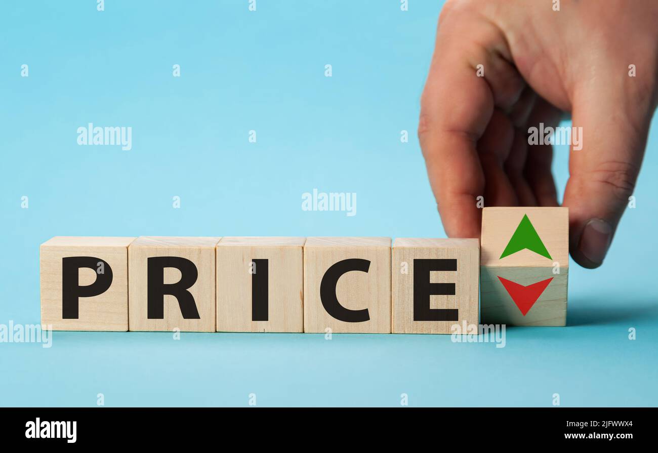 Price growth and decline. Hand changes the position of a block with ...