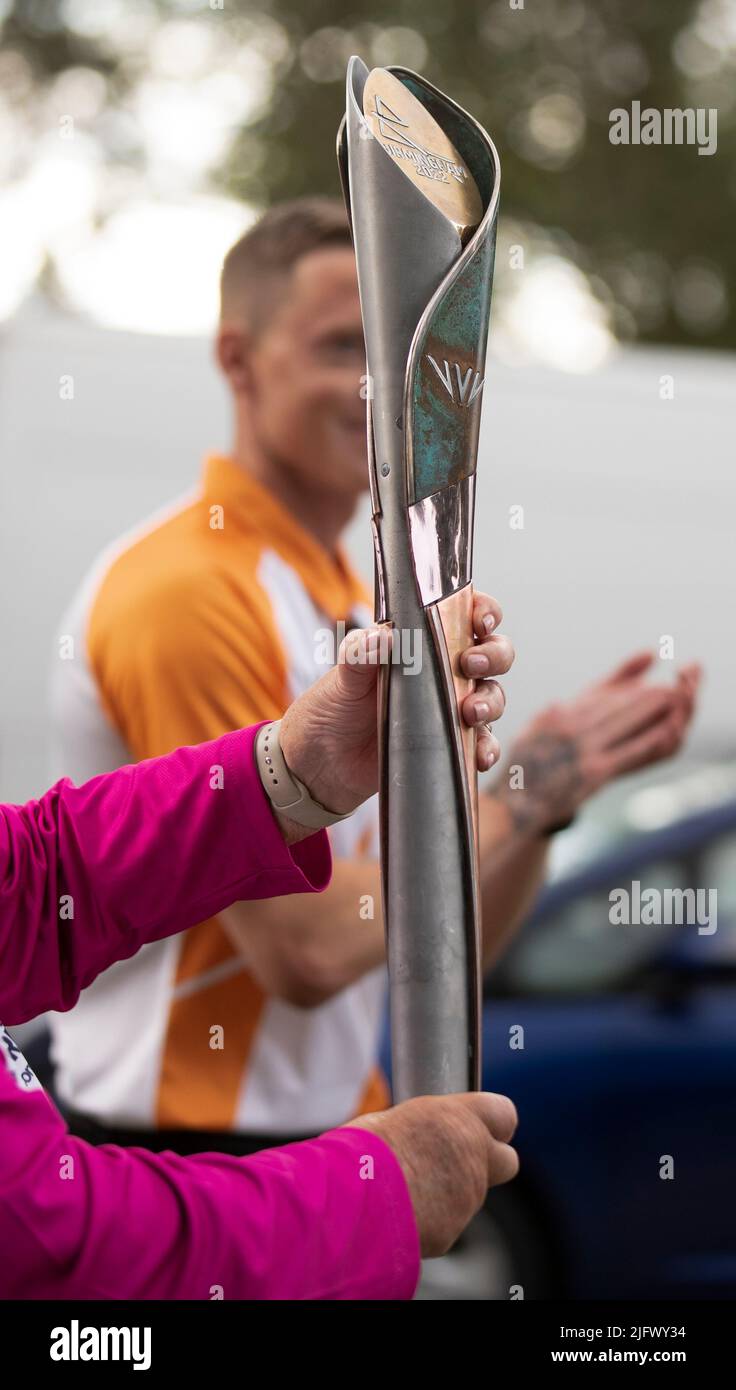 A Baton Bearer holds The Queen’s Baton during a visit from the ...