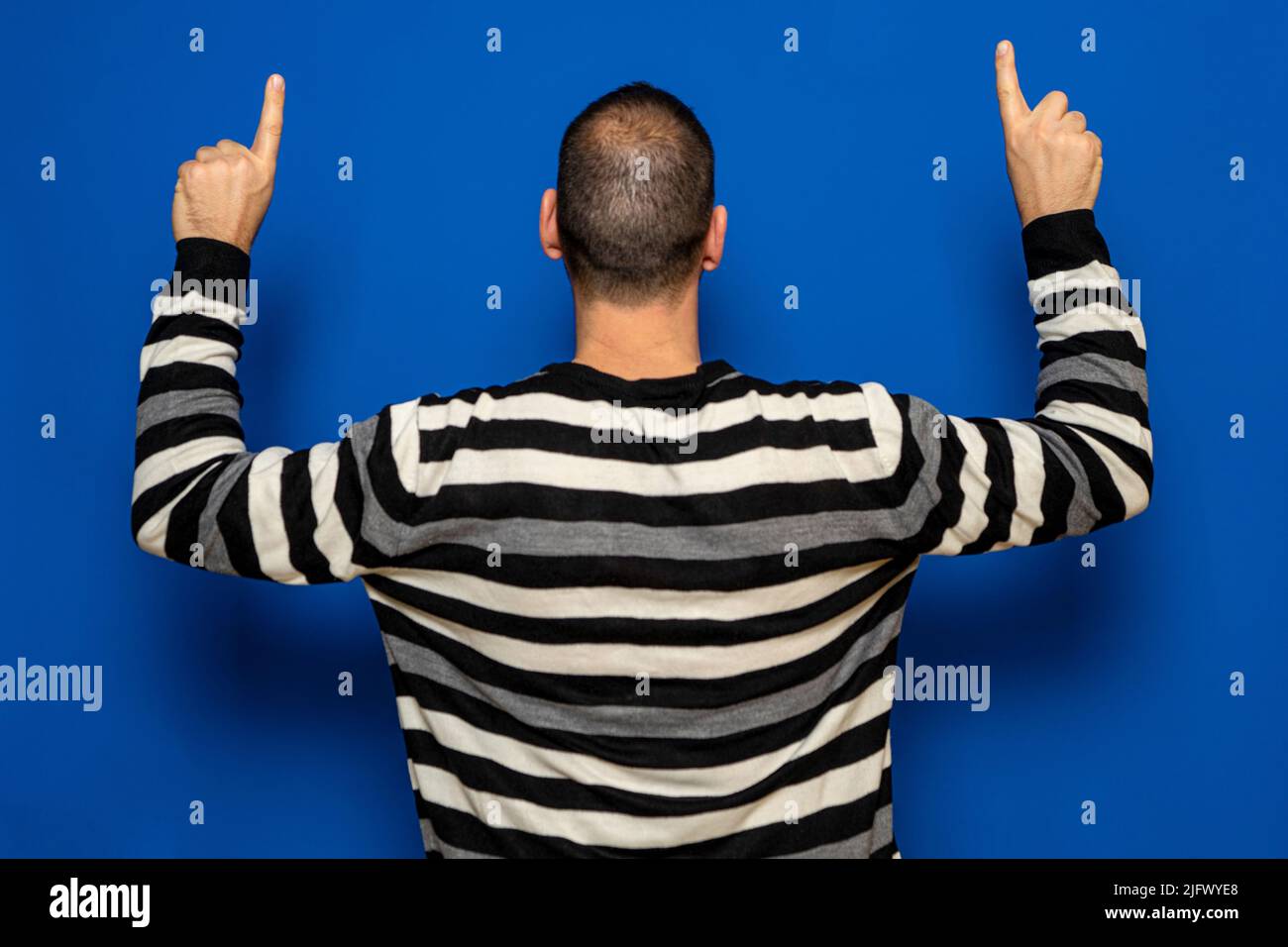 Hispanic man with receding hairline posing backwards pointing up with ...