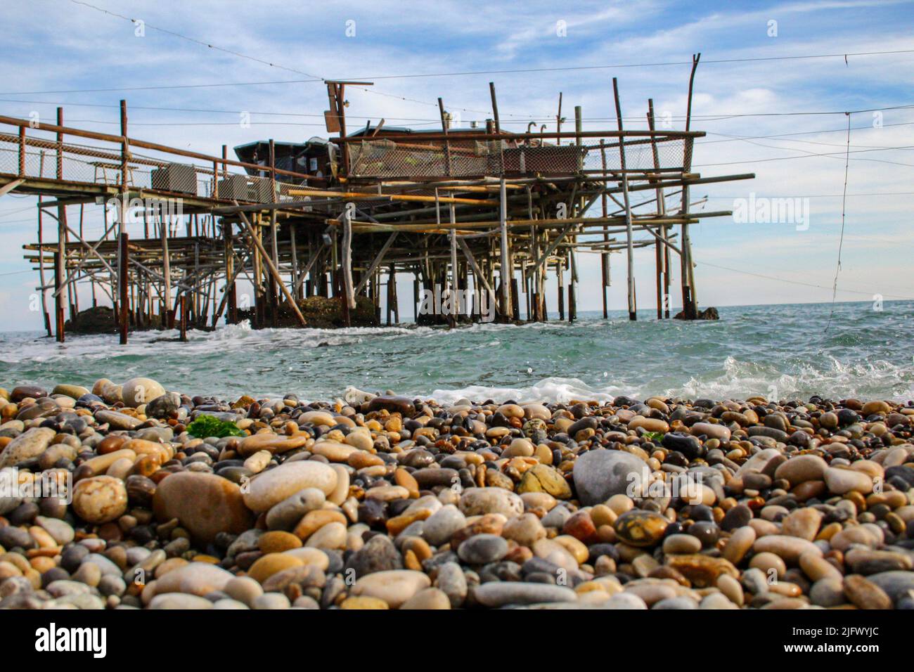 Image of a pebble beach with the sea and an overflow in the background ...