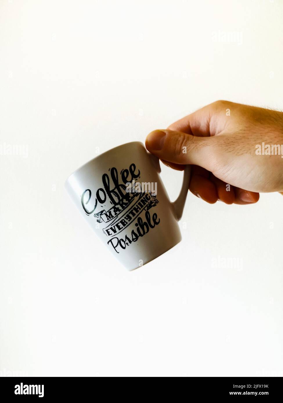 White cup with calligraphy lettering on it coffee makes everything ...