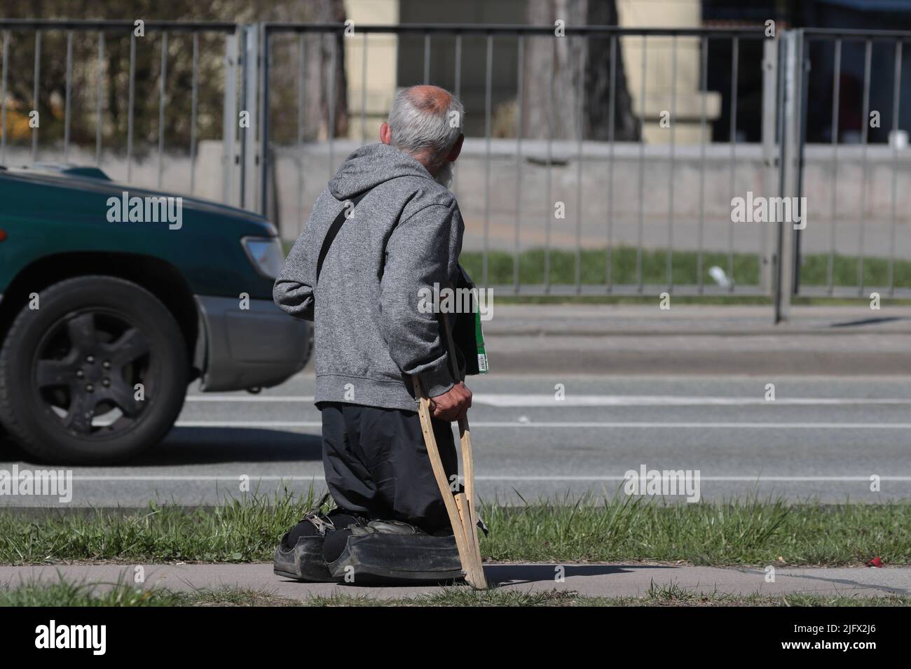 A physically disabled old man on crutches outdoors Stock Photo - Alamy