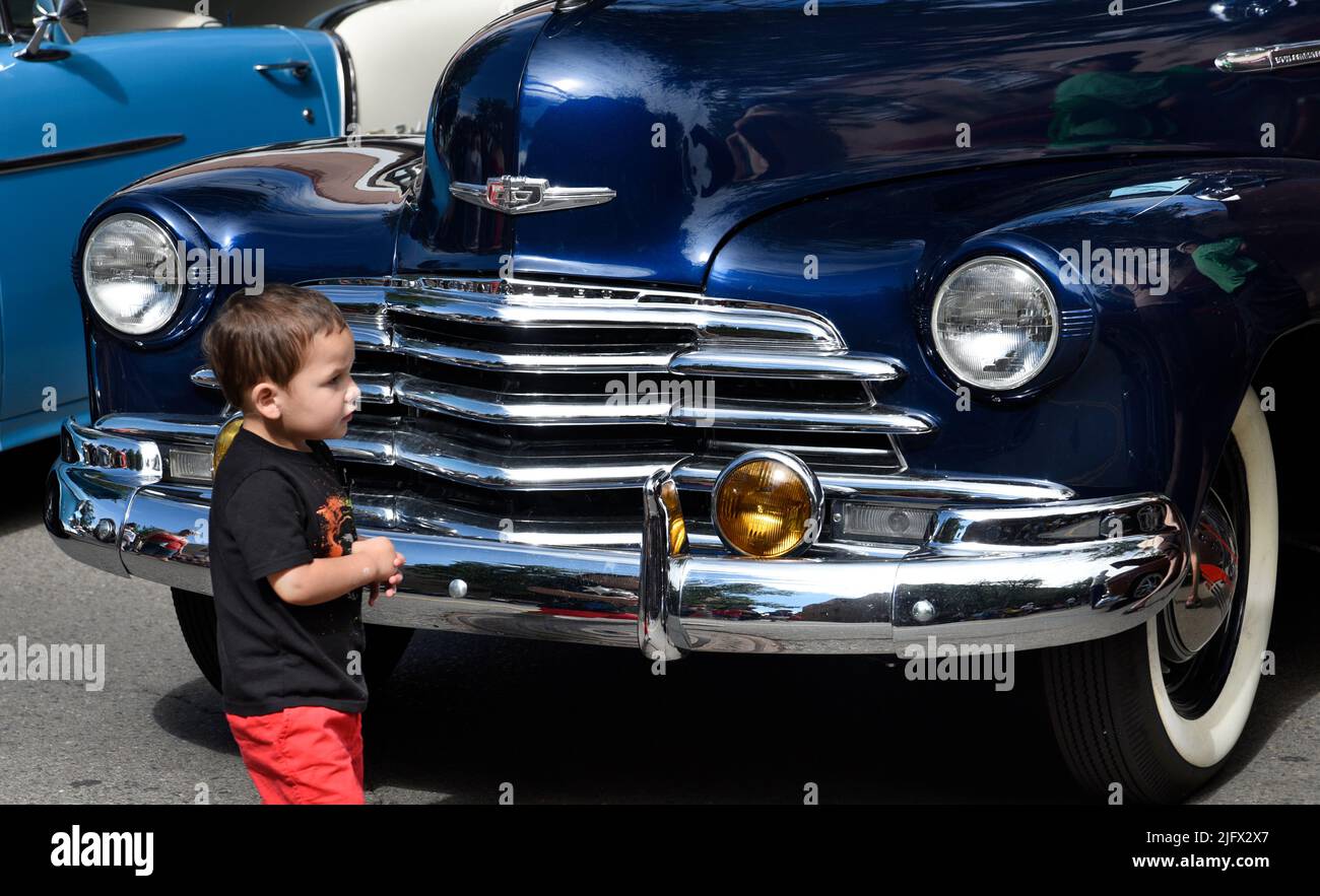 A young boy walks past a 1947 Chevrolet on display at a Fourth of July ...