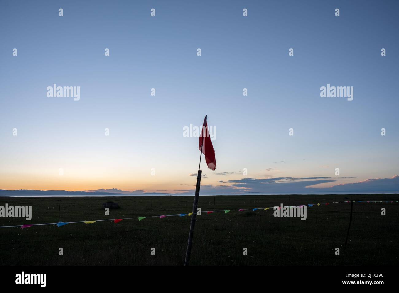 A border on the beach separated by different colored flags a large red ...