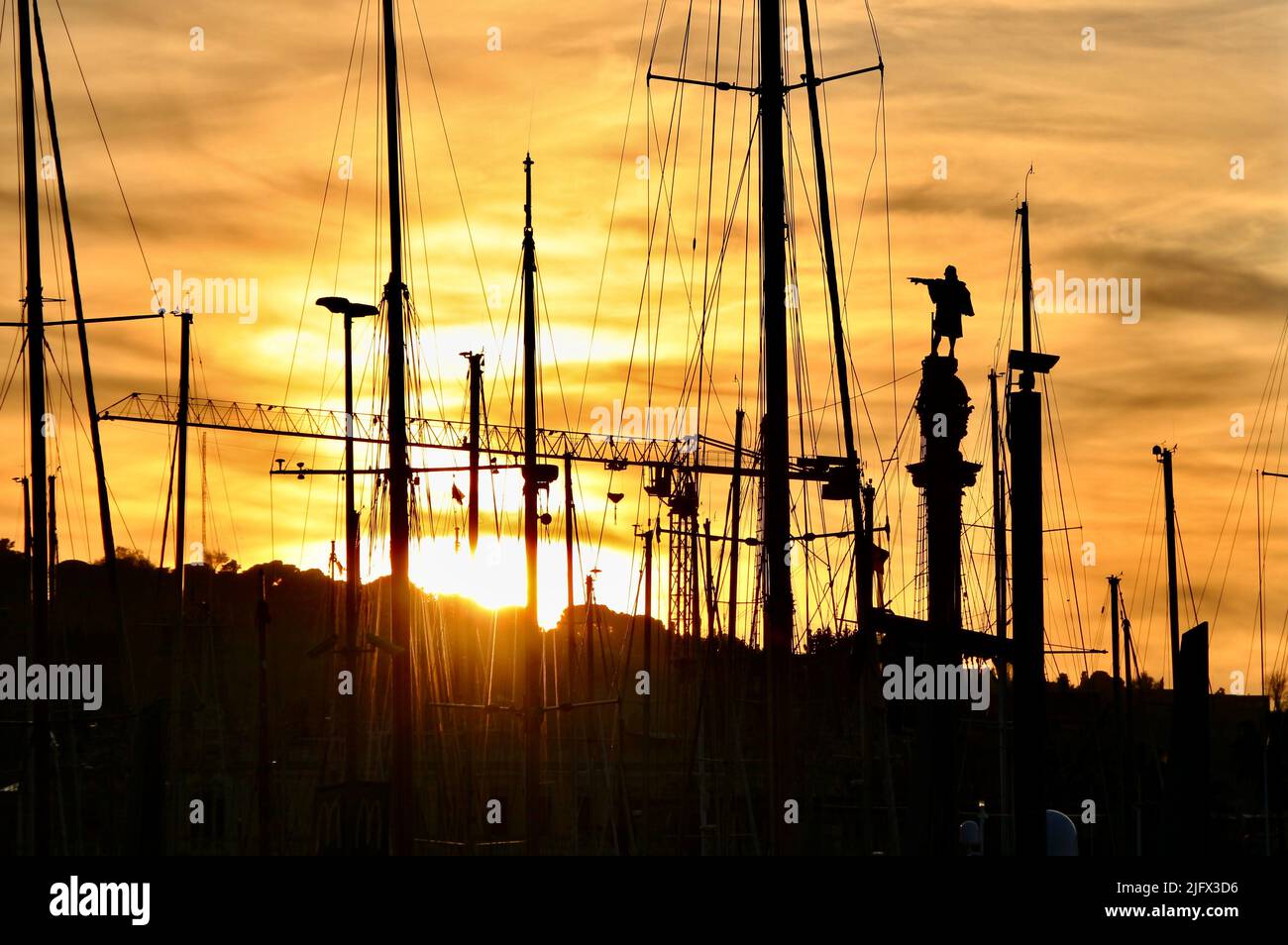 A statue of a man standing in a dock surrounded by the masts of sailing ...