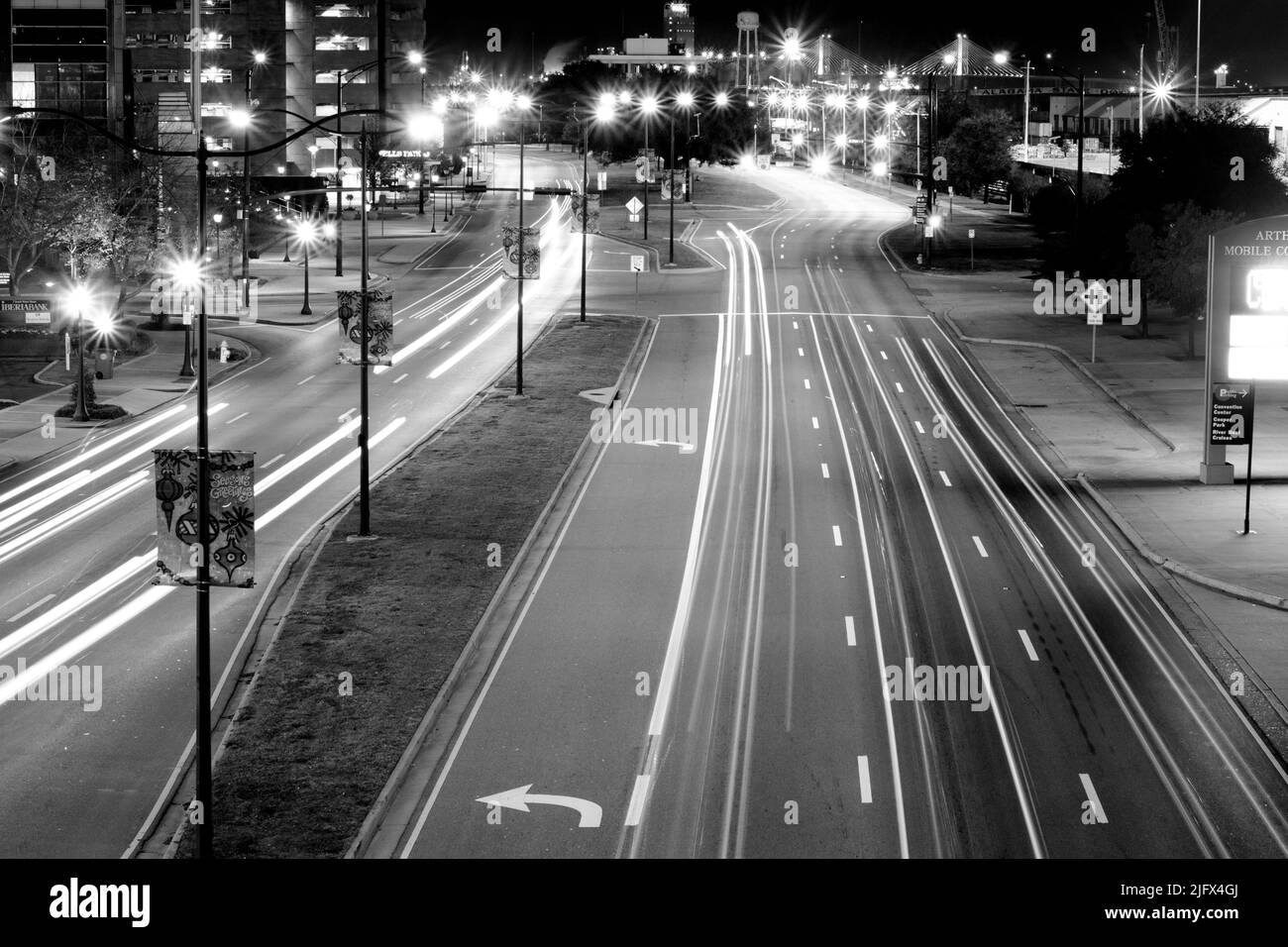 A grayscale of an empty road on downtown with streetlights on Stock ...