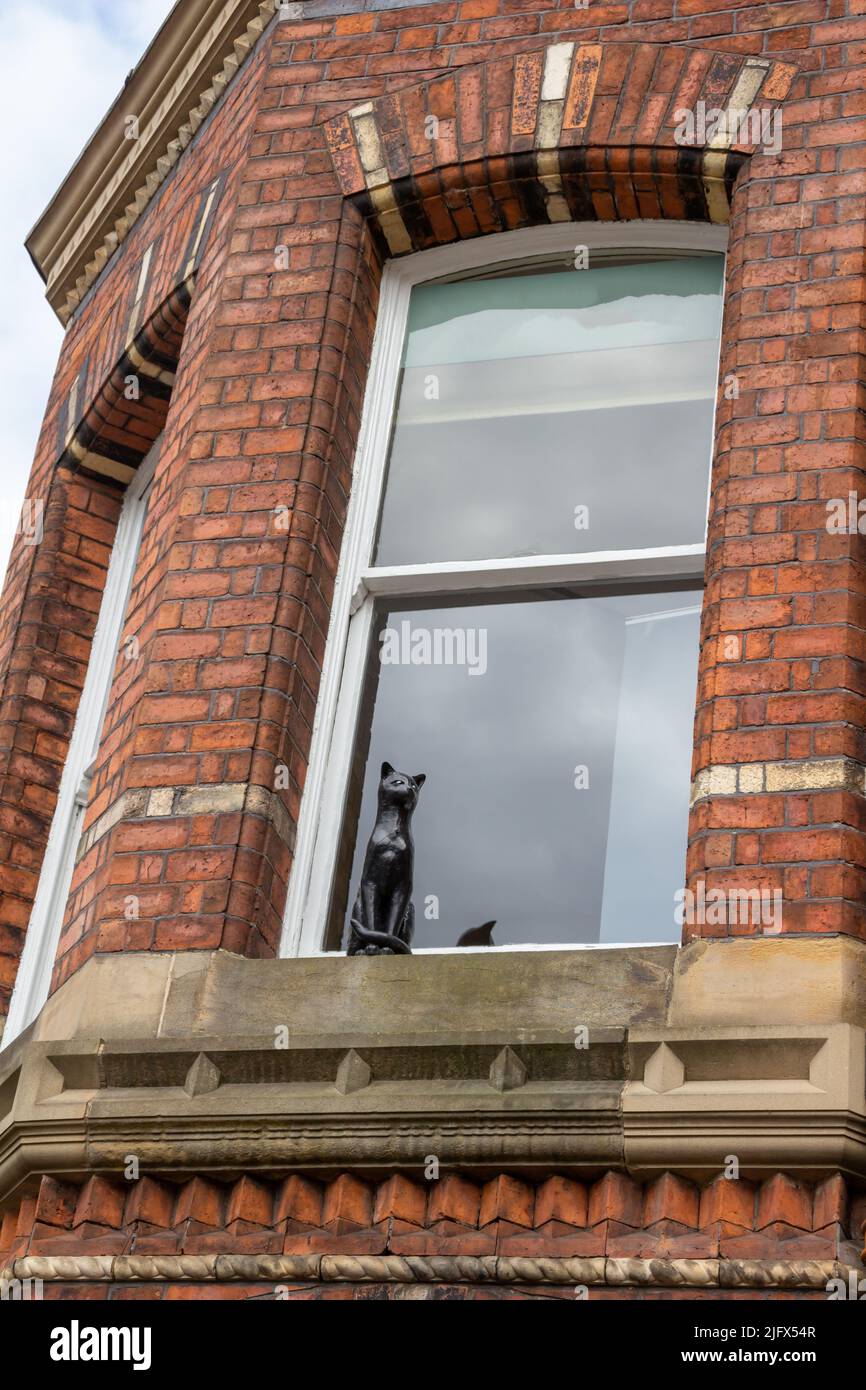 Closeup view of a European window on a corner brick building, with a ...
