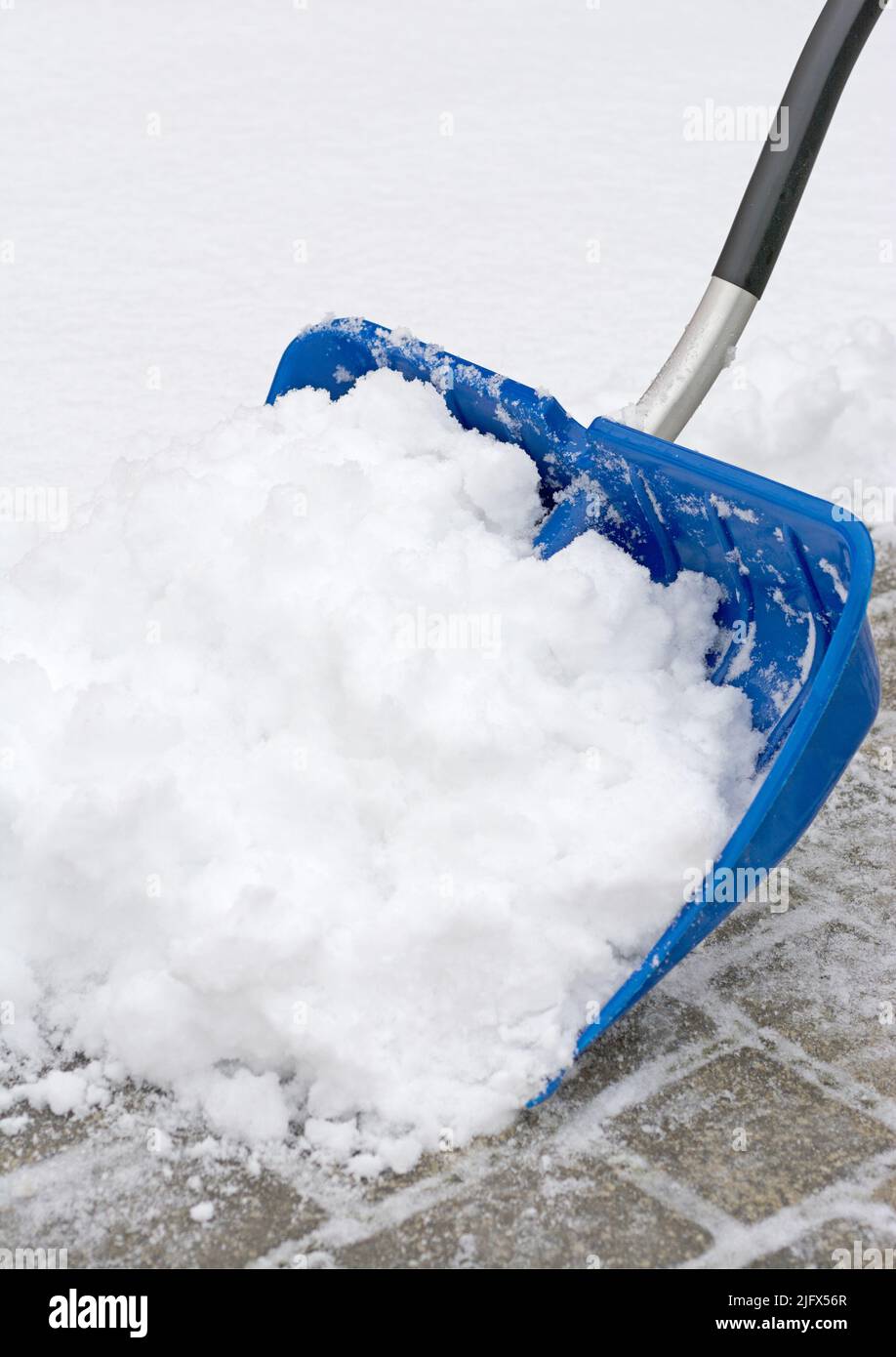 Snow shovel in action, portrait format Stock Photo - Alamy