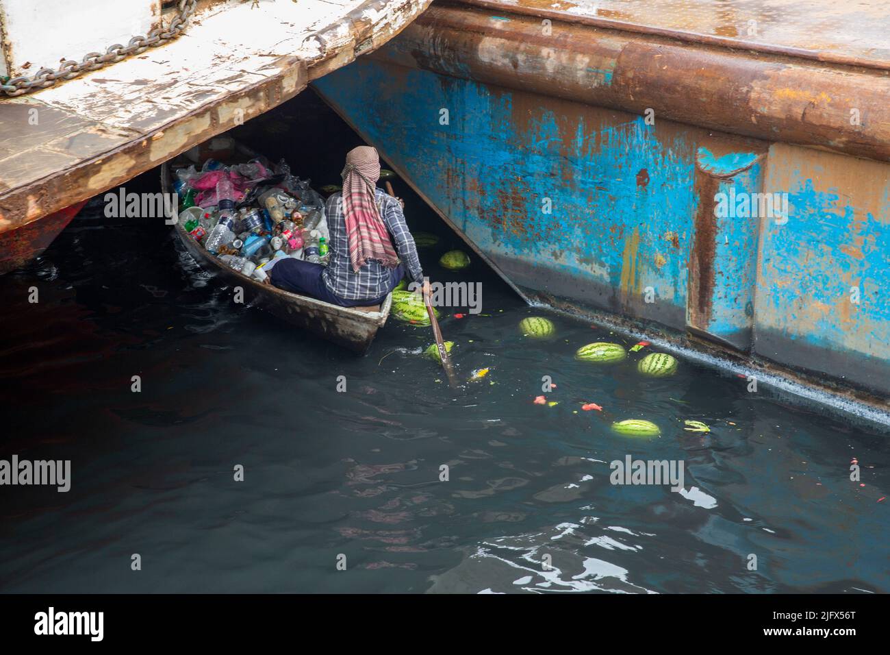 A man collects plastic waste form Buriganga River, Dhaka, Bangladesh ...