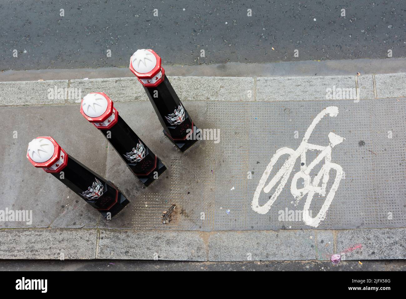 Row of colourful bollards and bicycle traffic sign. City of London ...