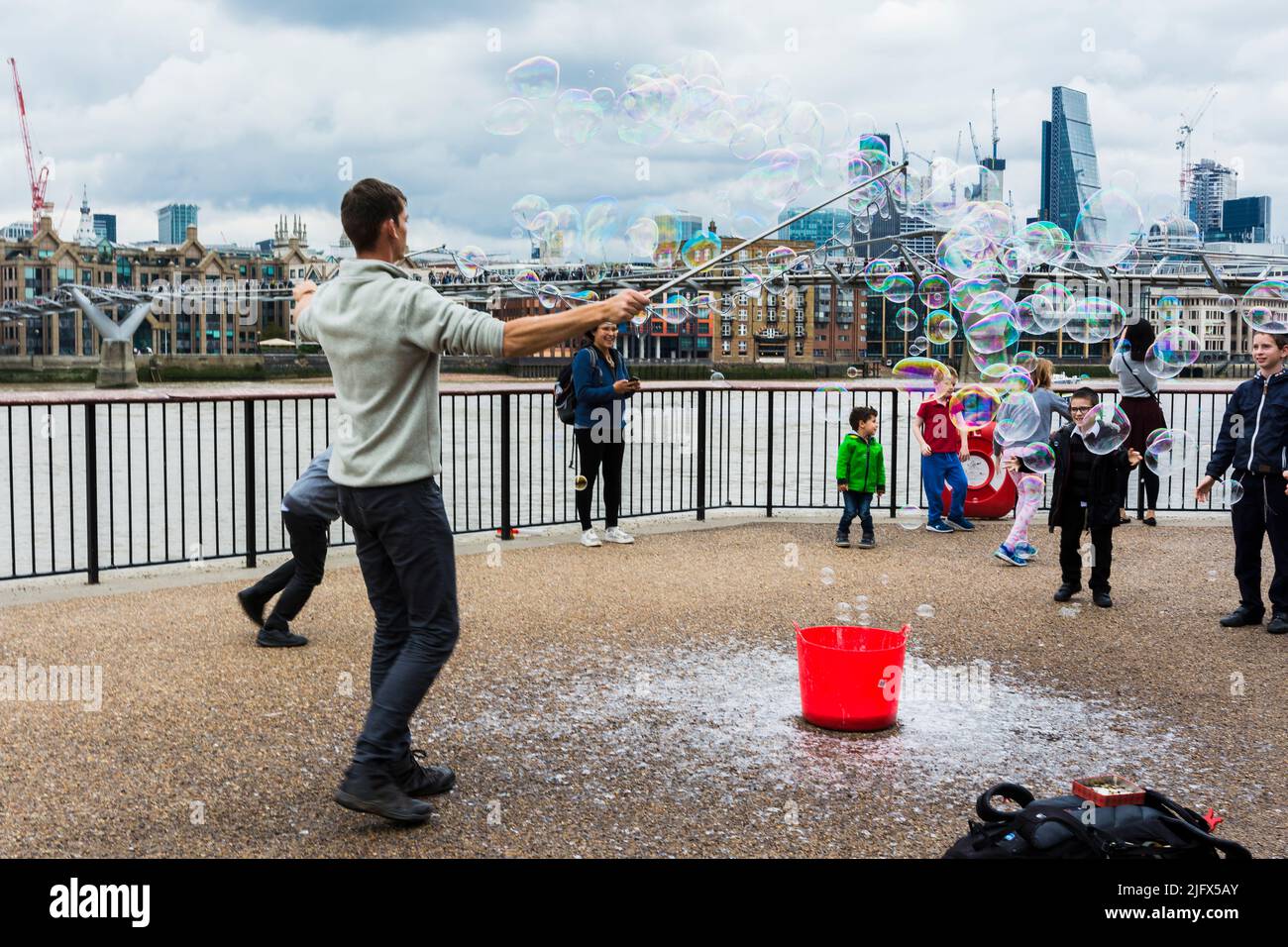 Street performer on the South Bank blowing bubbles for children. London ...