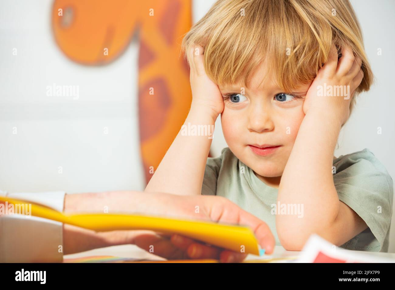 Little boy with thoughtful look stare at the page in book Stock Photo ...