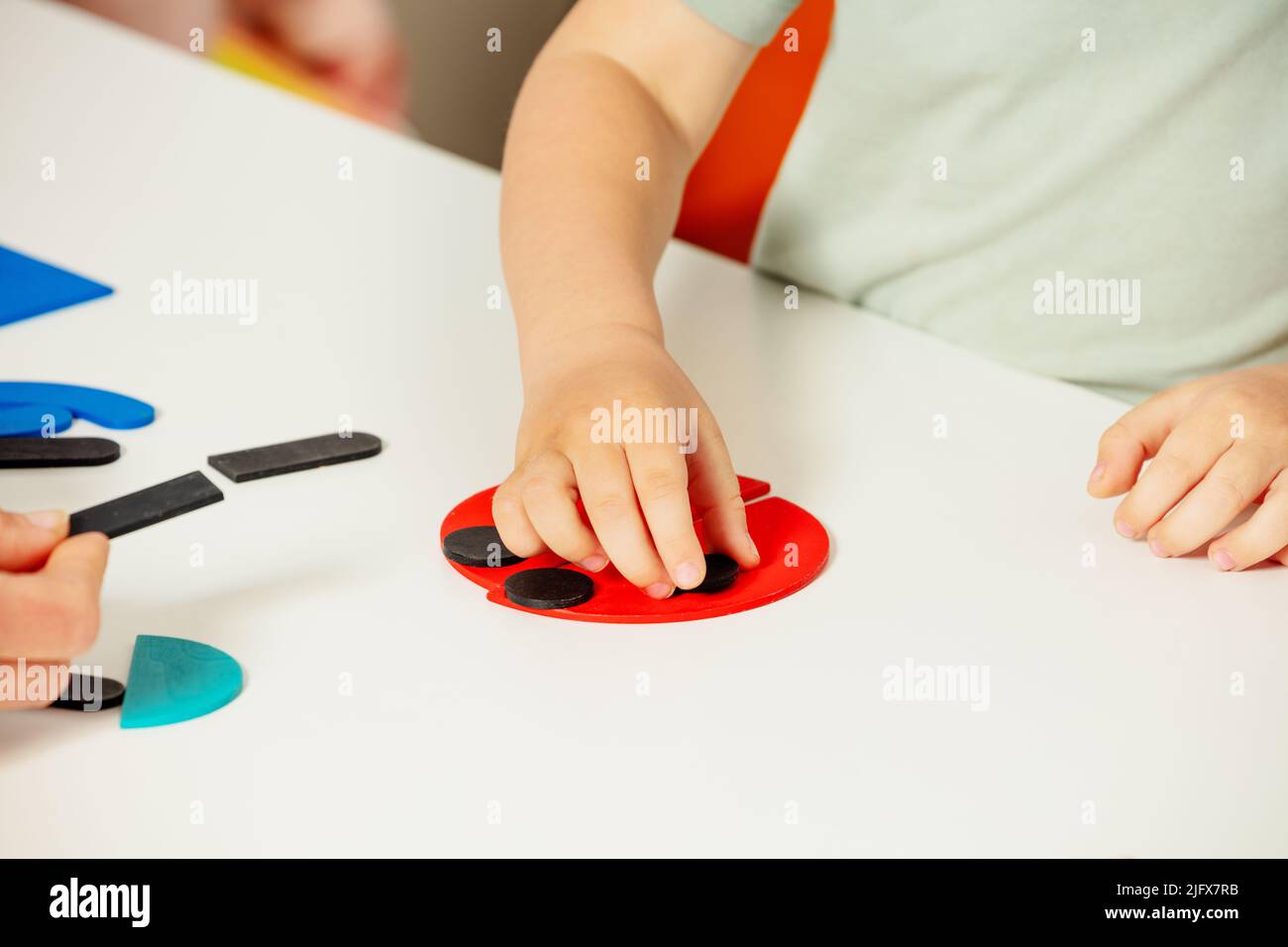 Kids hand put together shapes to create a bug Stock Photo - Alamy