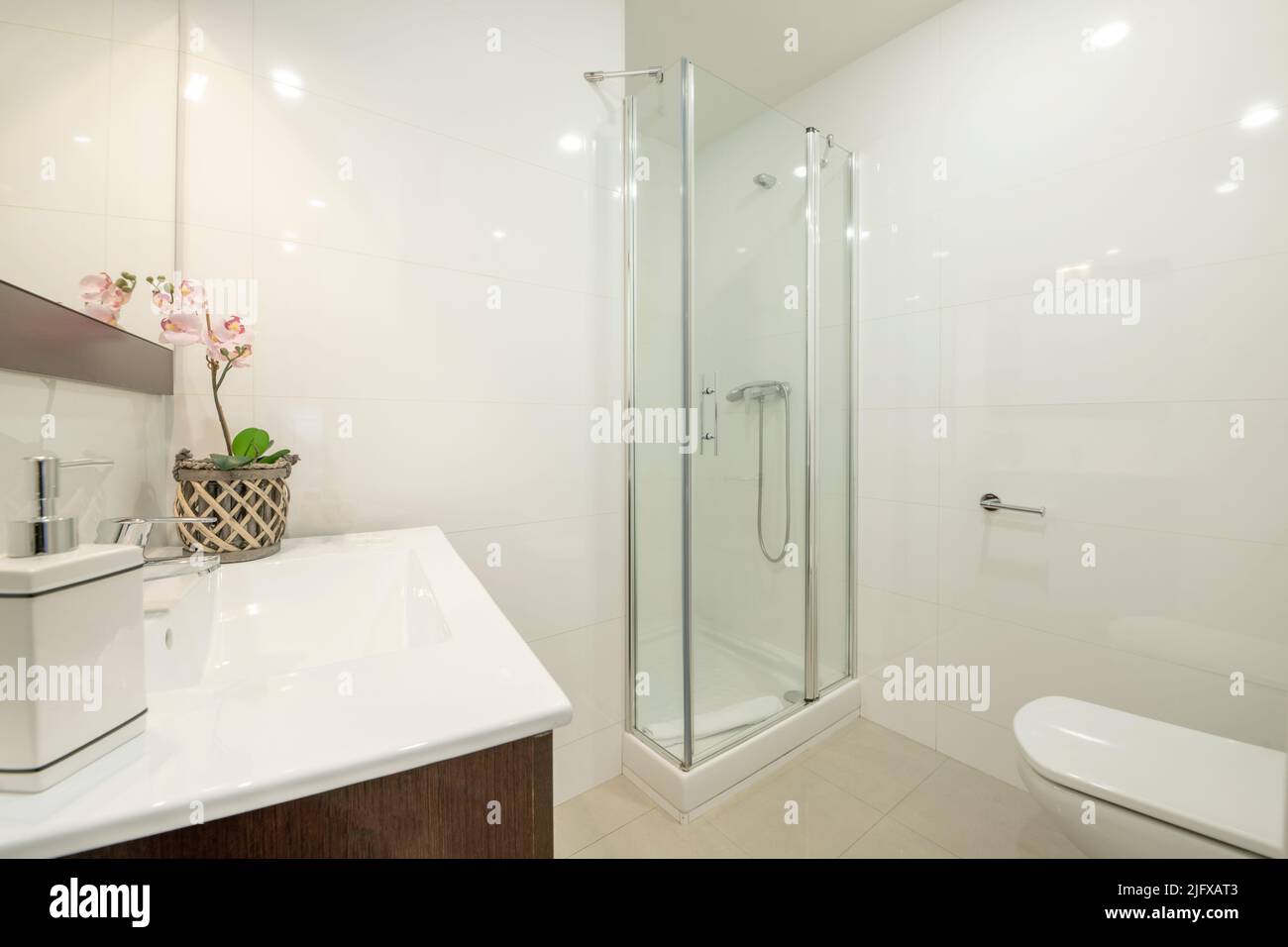 Bathroom decorated with a square shower cabin with wooden furniture and ...
