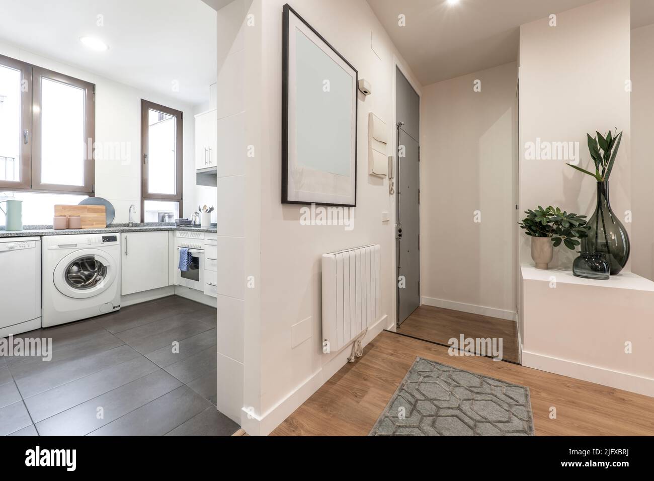 Entrance hall of a house with an open kitchen with white furniture with ...