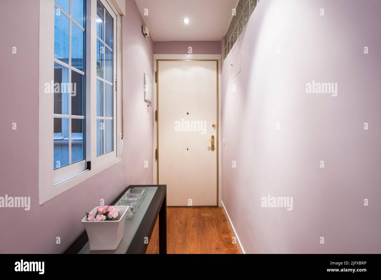Entrance hall of a house with smooth walls painted in pink with a wood ...