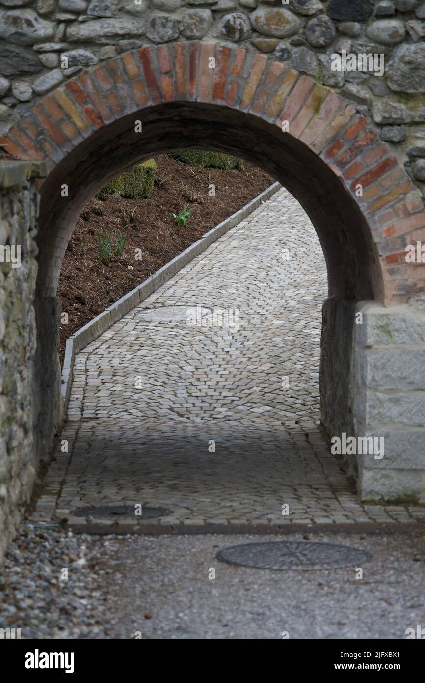 A view of a road with a small stone arch in a park Stock Photo - Alamy