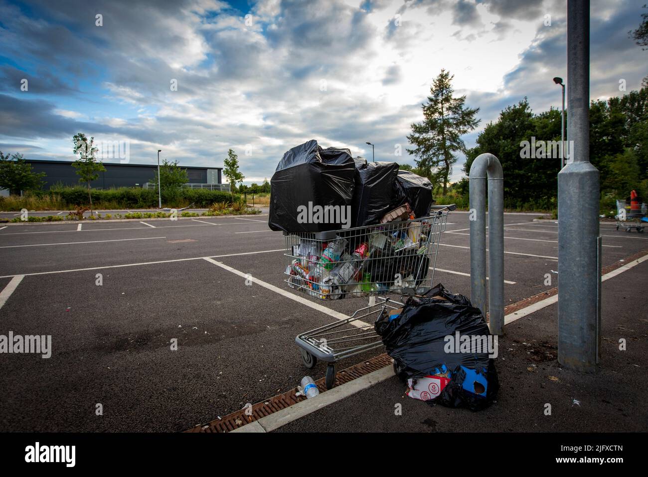 Shopping trolleys filled with rubbish on the edge of a shopping park ...