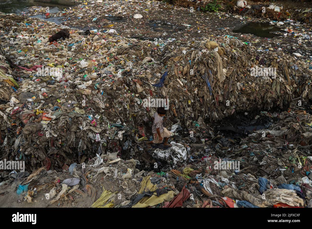 New Delhi, India. 29th June, 2022. A young boy walks down a heap of ...