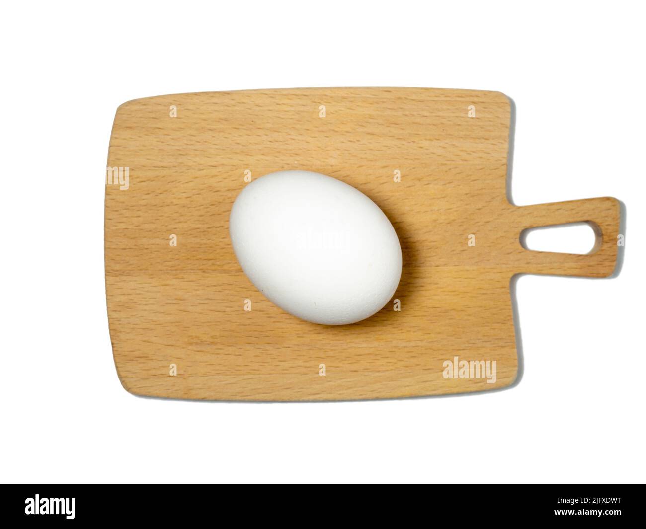 Egg on a cutting board on a white background. Unpeeled egg. In shell ...