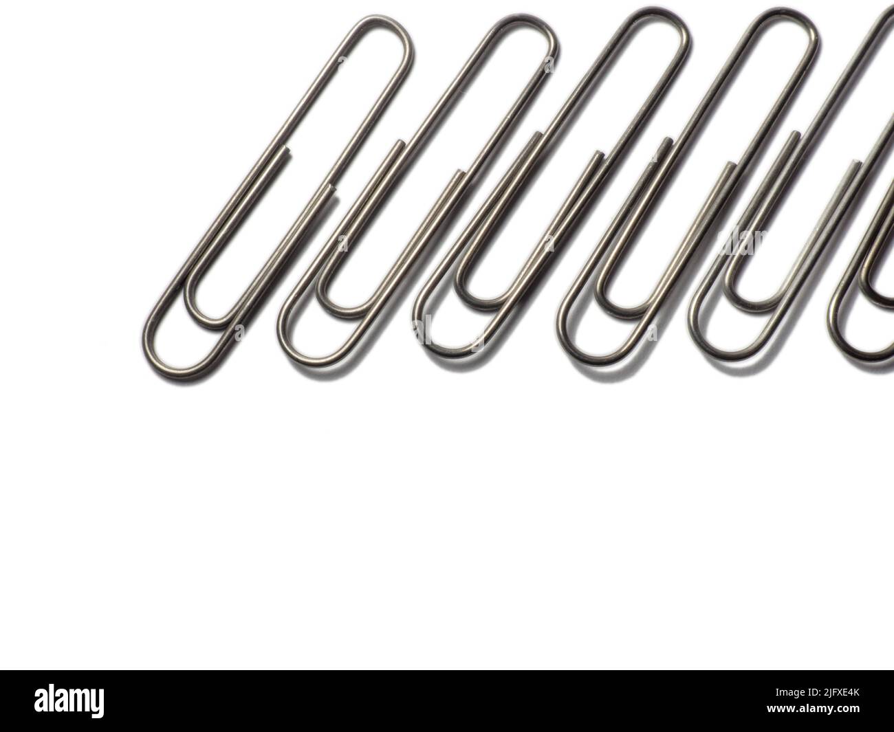 Metal paper clips on a white background. office supplies isolate Stock ...