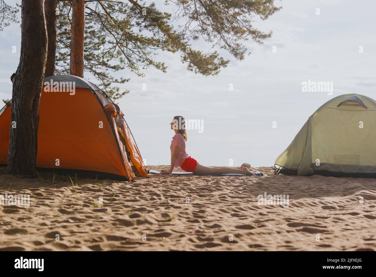 Performing Urdhva Mukha Svanasana pose in a tent camp Stock Photo - Alamy