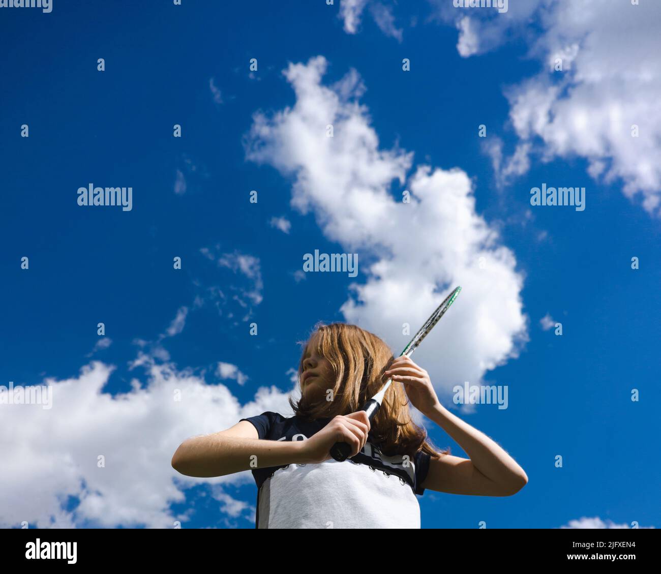 Young girl holding badminton racket with hands on sky background Stock ...