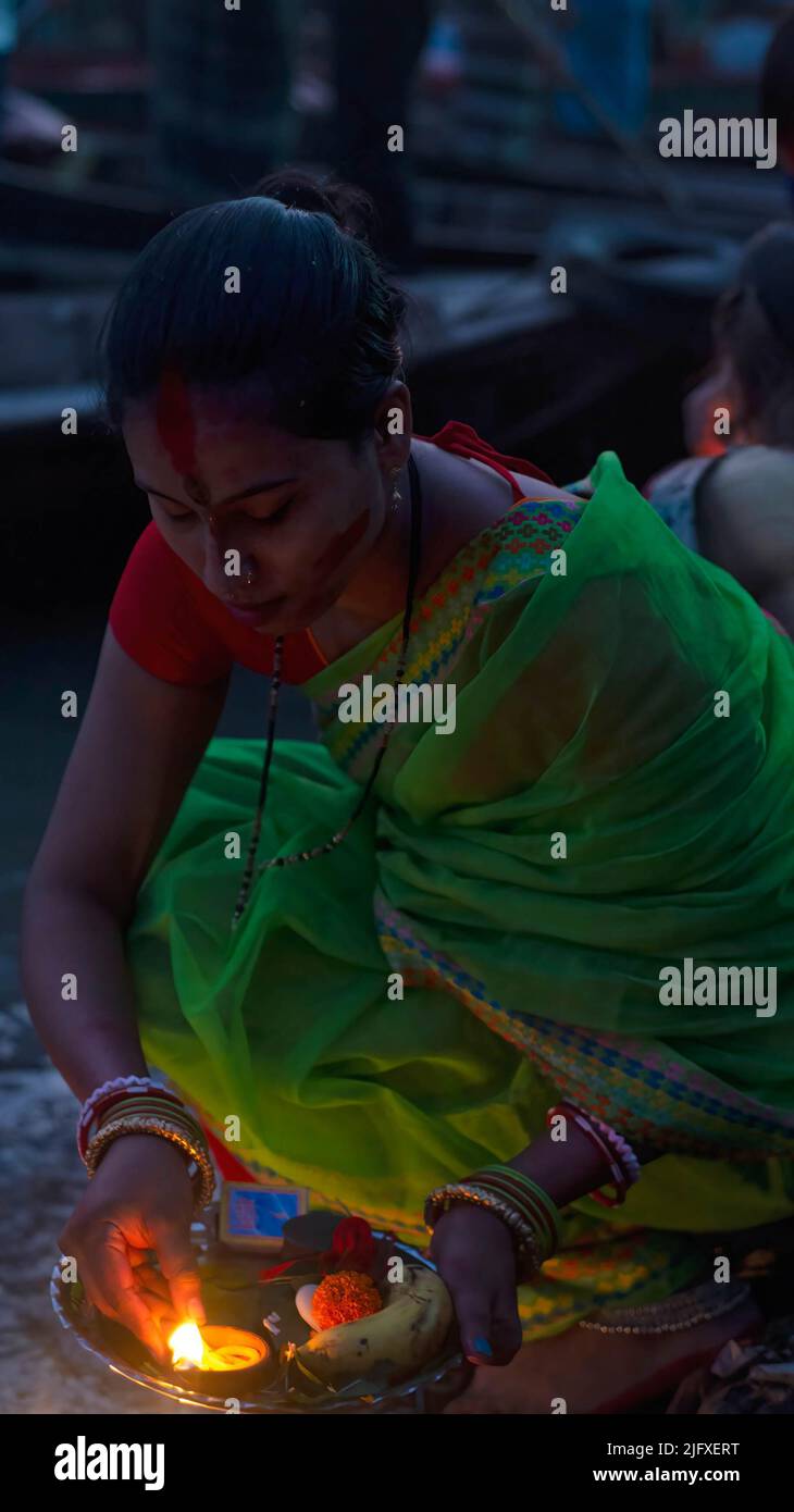 Dhaka, Bangladesh. 05th July, 2022. A Hindu devotee prepares to float her lamp on river ...