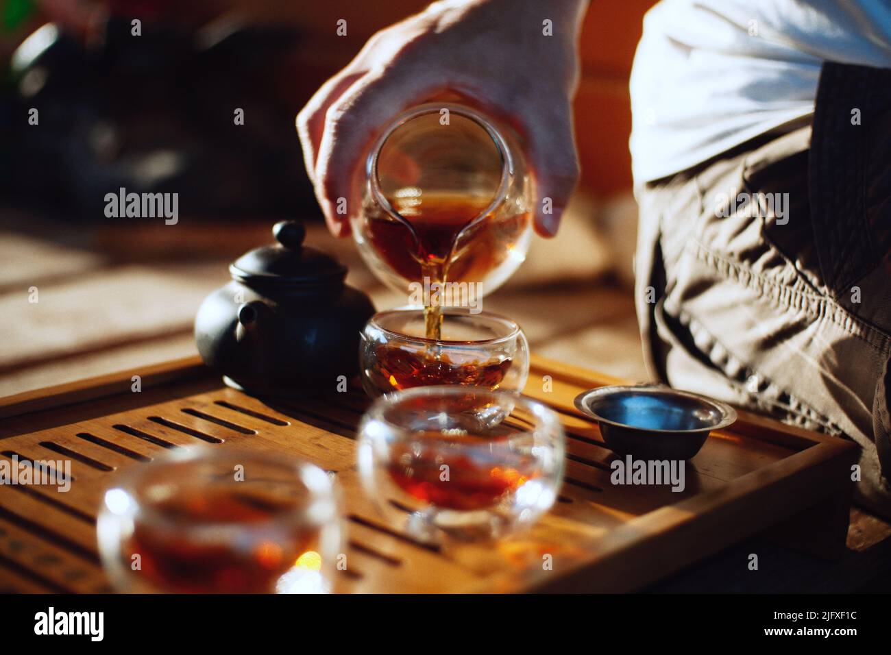 male hands pour Chinese tea into a glass bowl Stock Photo - Alamy