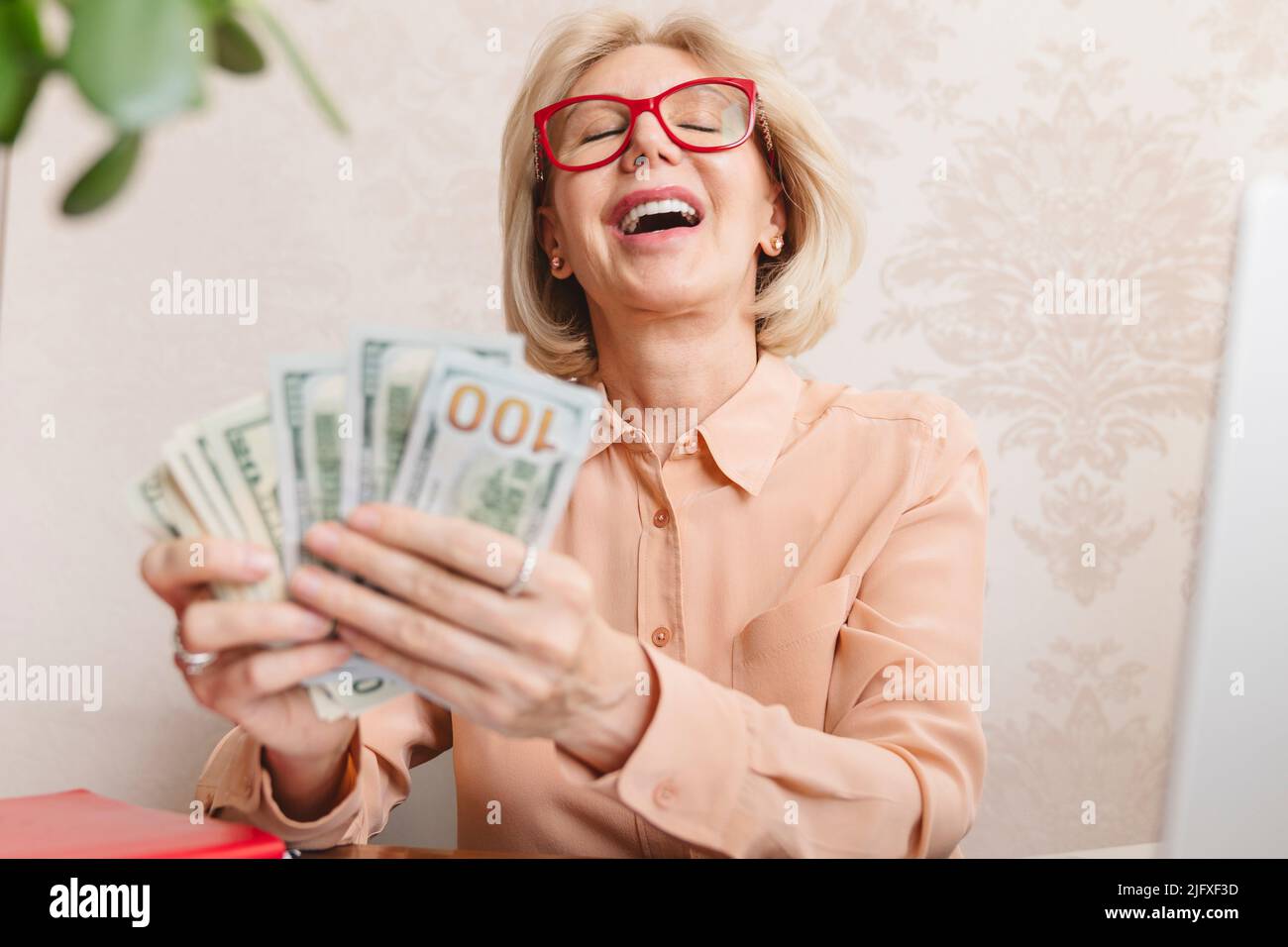 A happy woman with cash dollars in her hands Stock Photo - Alamy