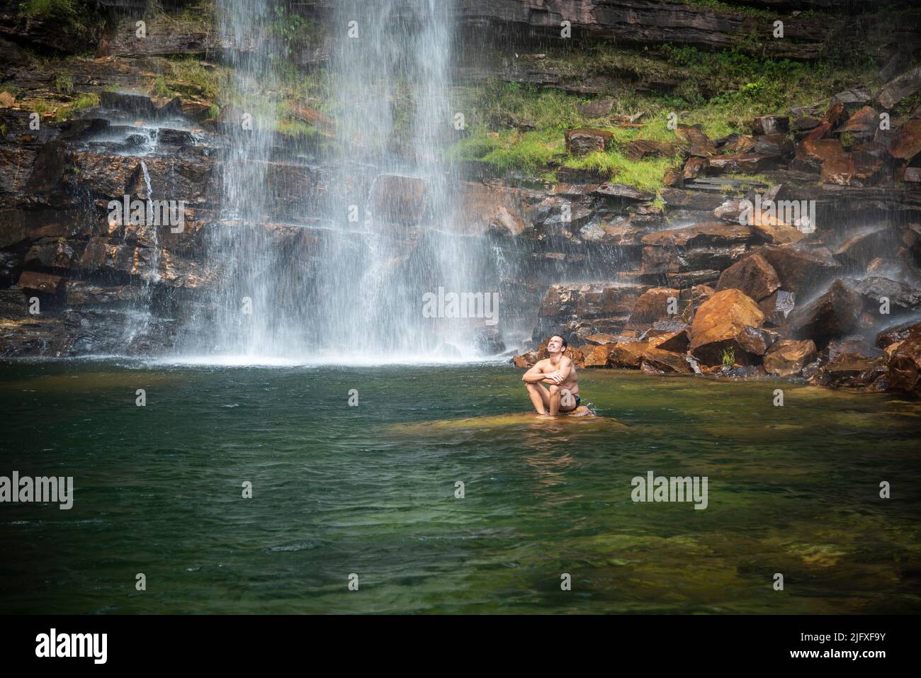 Beautiful view to man enjoying big natural wild waterfall Stock Photo ...