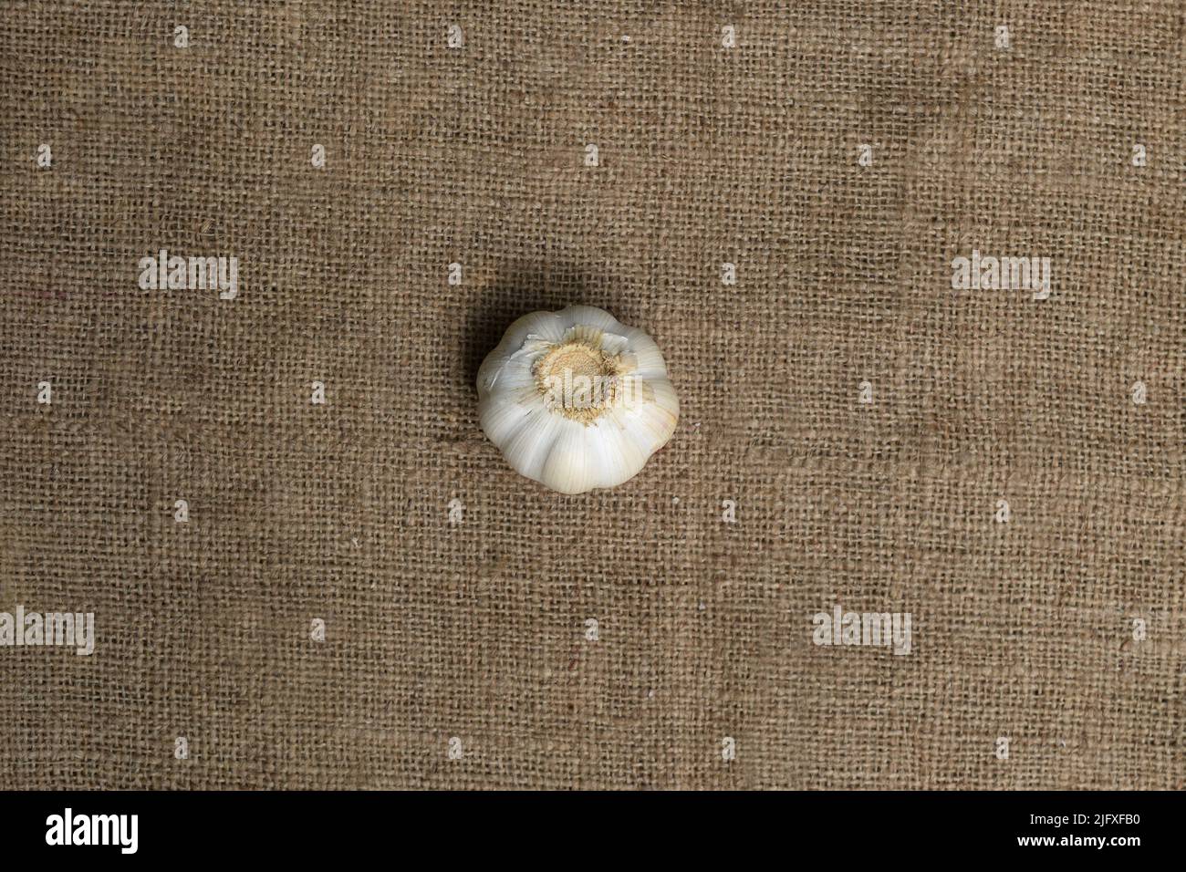 Garlic on jute fabric background. Spices for cooking meat Stock Photo ...