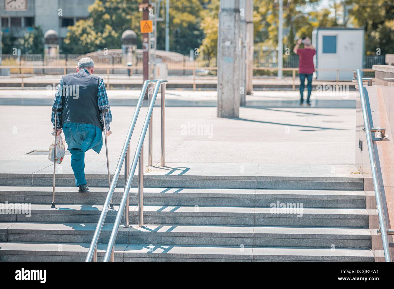 Older man without a leg, invalid or disabled person with crutches ...