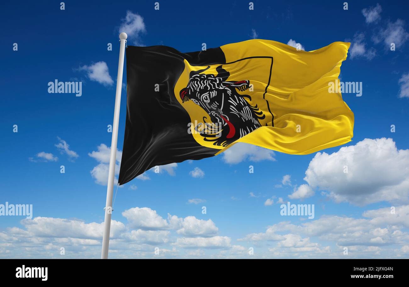 official flag of Vils Austria at cloudy sky background on sunset ...