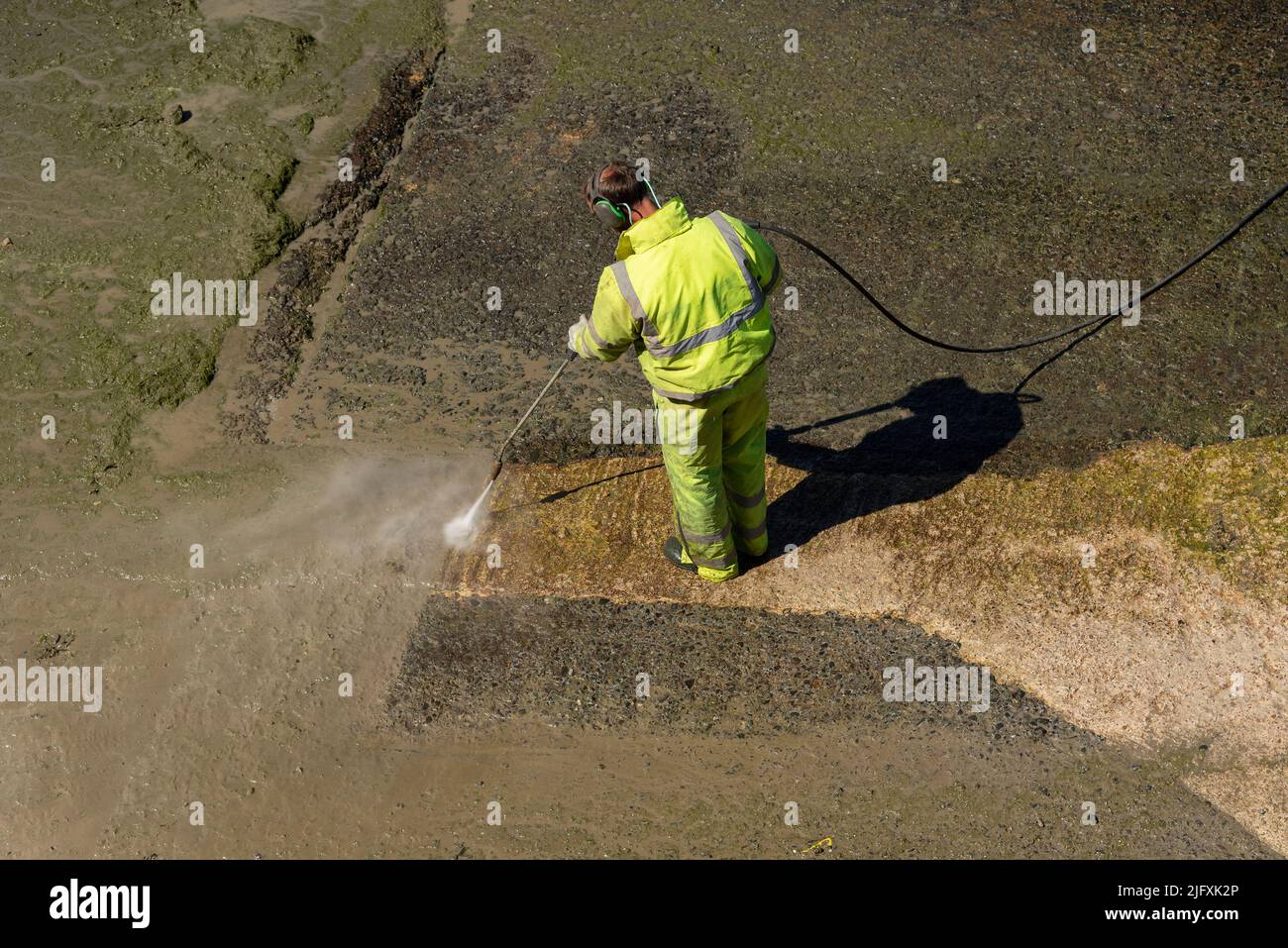 Penzance, Cornwall, England, UK. 2022. Man using a pressure washer at ...