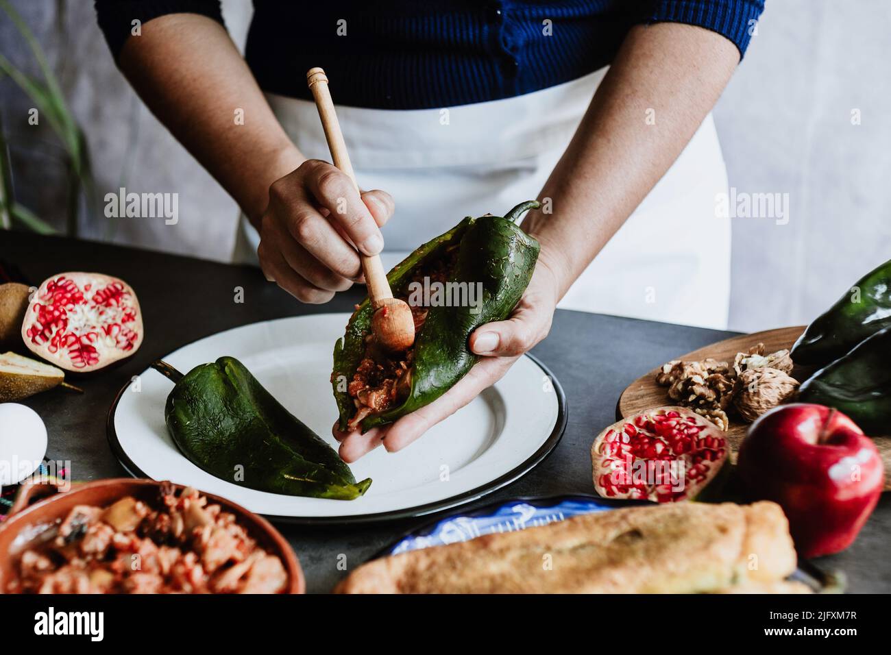 mexican woman cooking chiles en nogada recipe with Poblano chili and ...