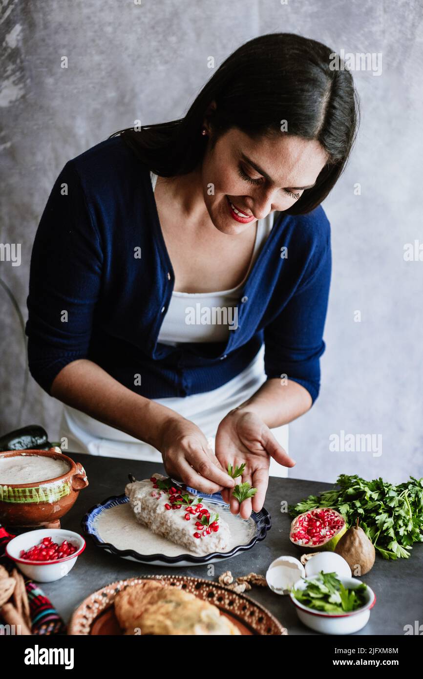 mexican woman cooking chiles en nogada recipe with Poblano chili and ...