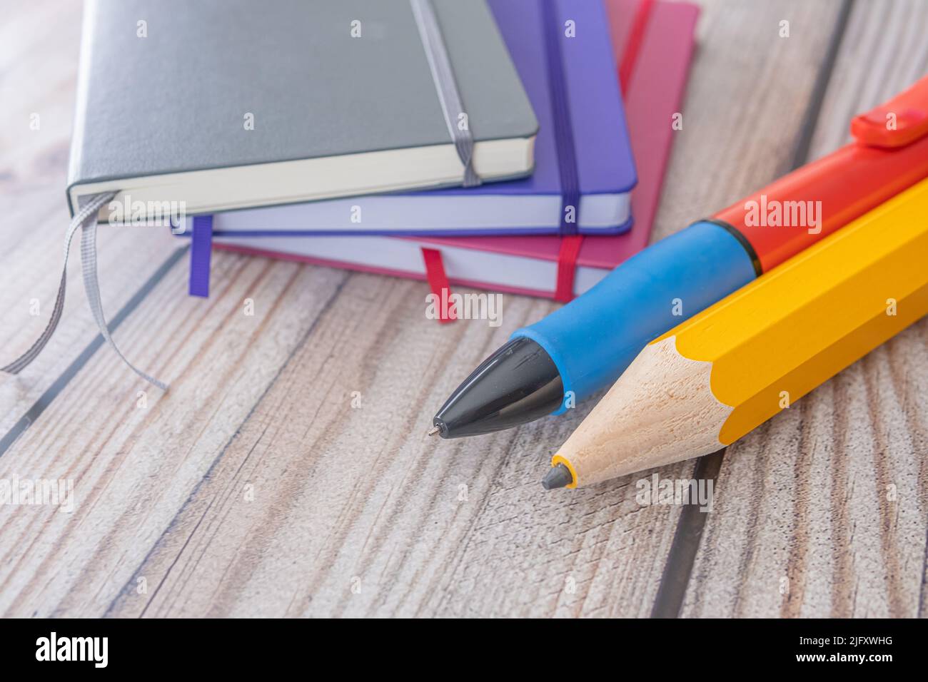 Stack of Journals notebooks with giant pen and pencil Stock Photo - Alamy