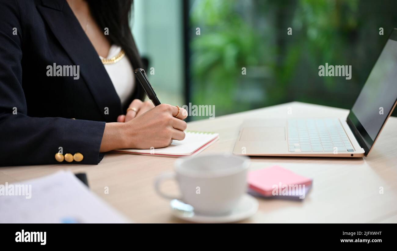 A successful businesswoman or female executive manager writing or ...