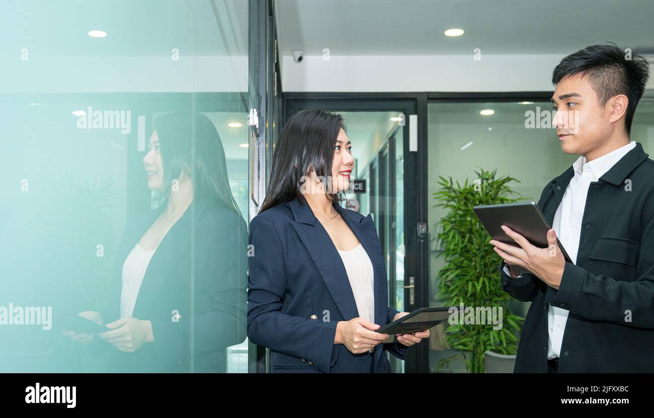 Business people holding digital tablet and talking to each other ...