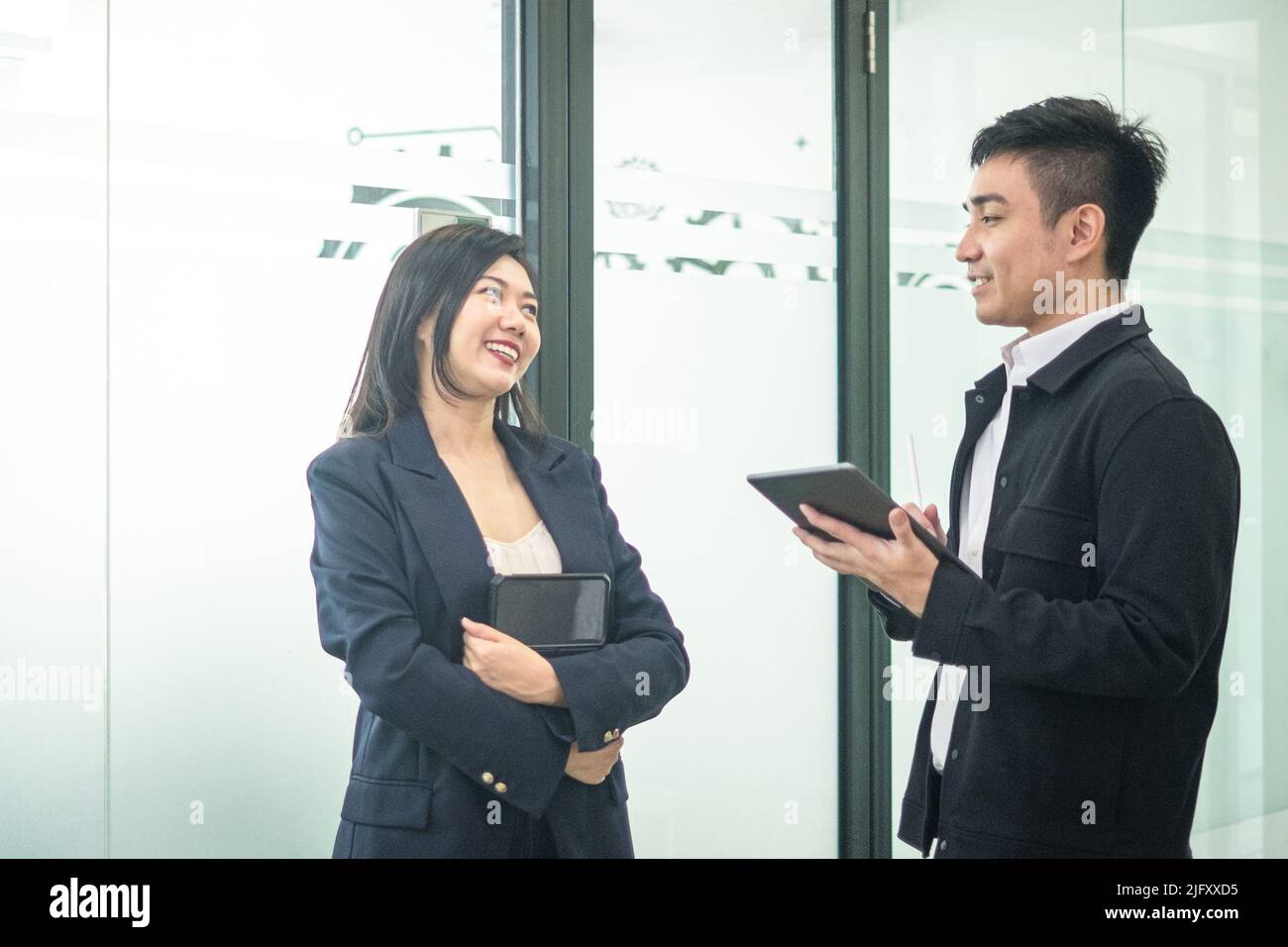 Business people holding digital tablet and talking to each other ...