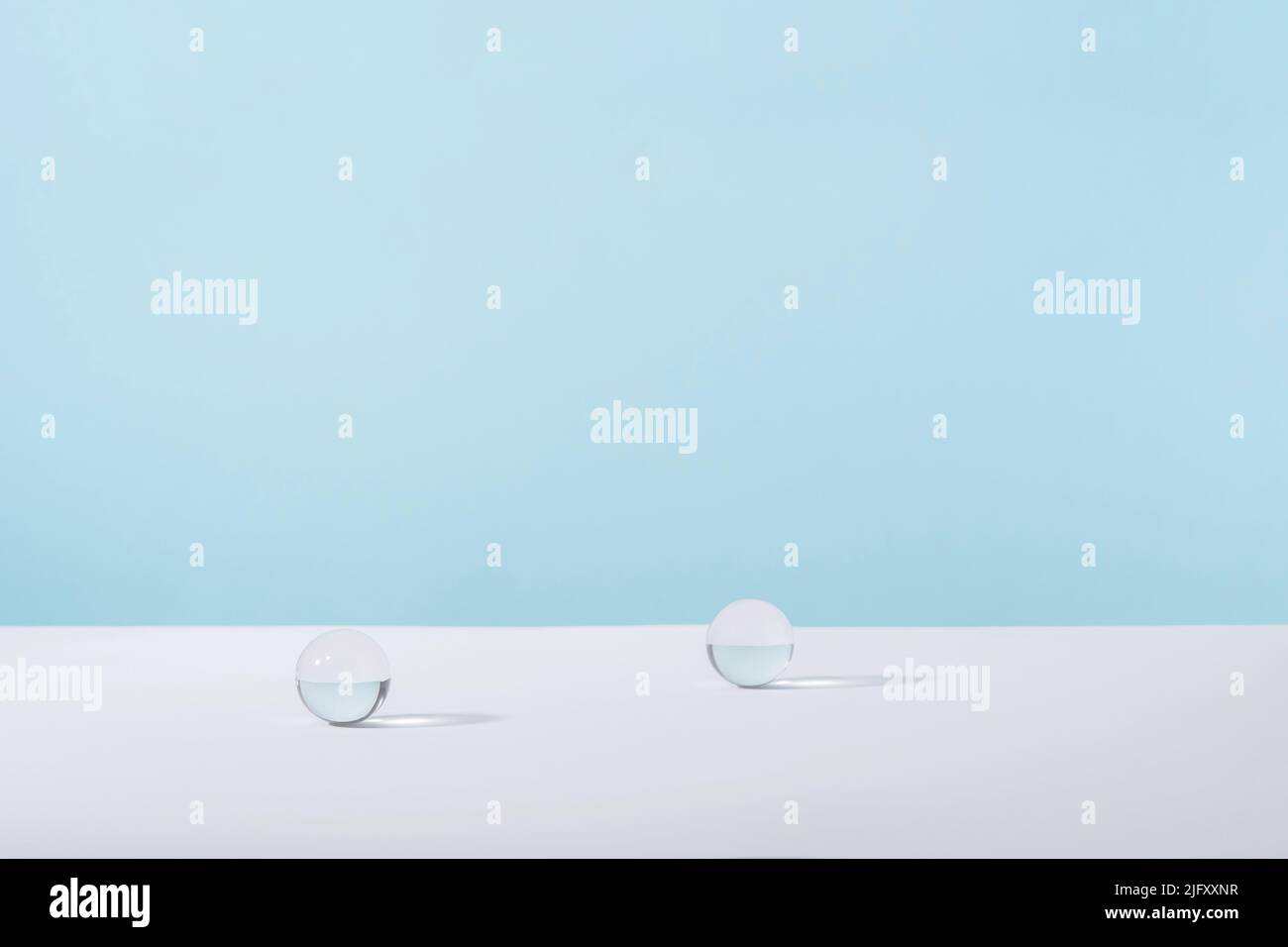 Acrylic glass spheres on blue background for cosmetic or perfume ...