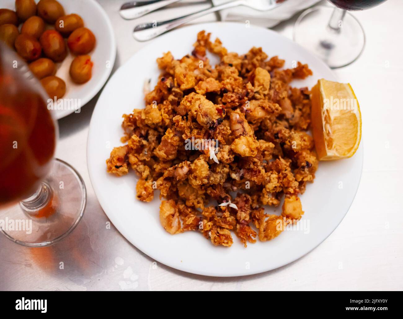 Chipirones, breaded fried calamari with lemon Stock Photo - Alamy