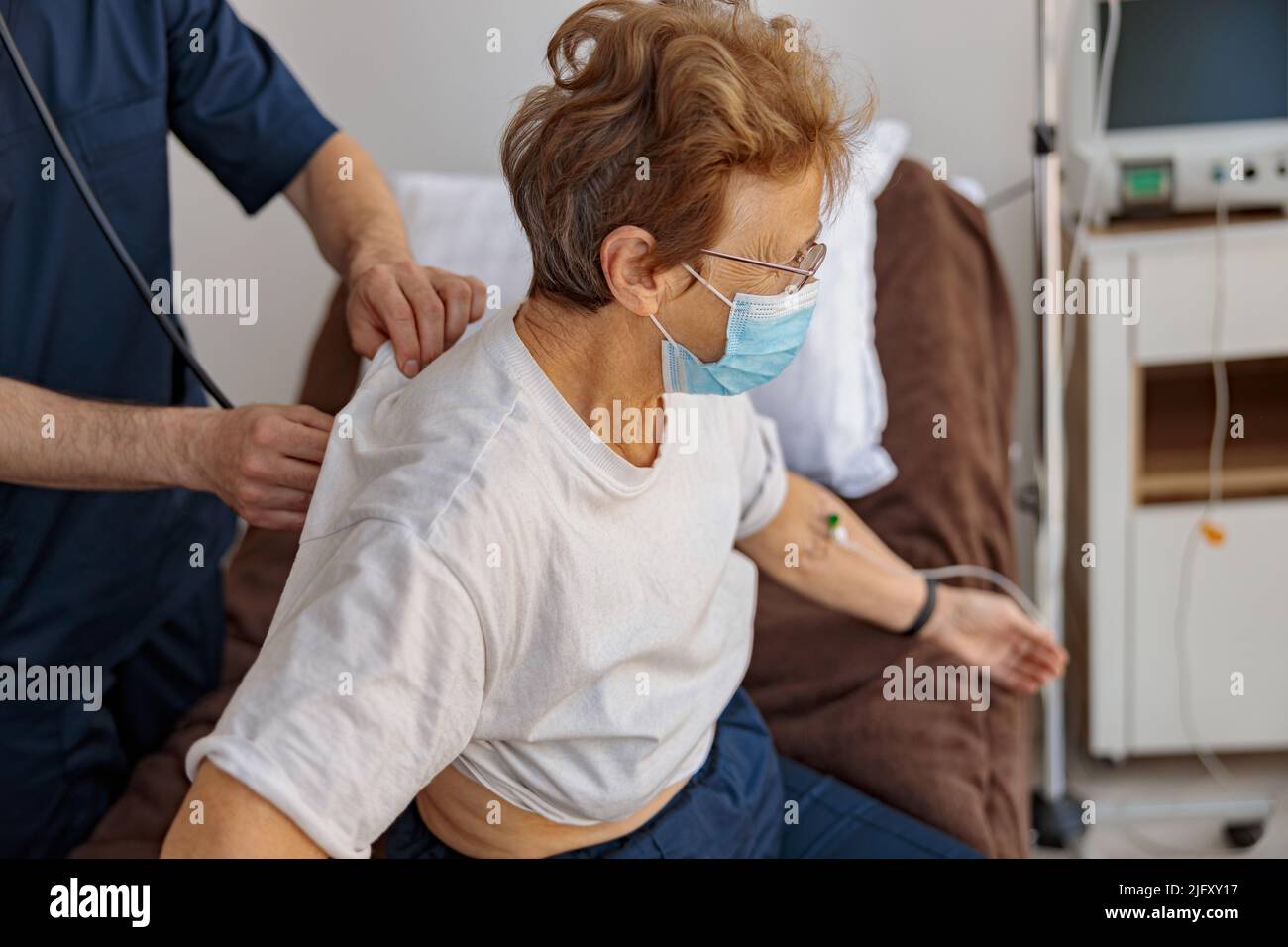 Doctor listening to old woman's patient breathing, using stethoscope ...