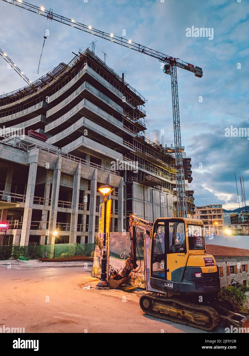 Tower crane at the construction site of an apartment building at dusk ...