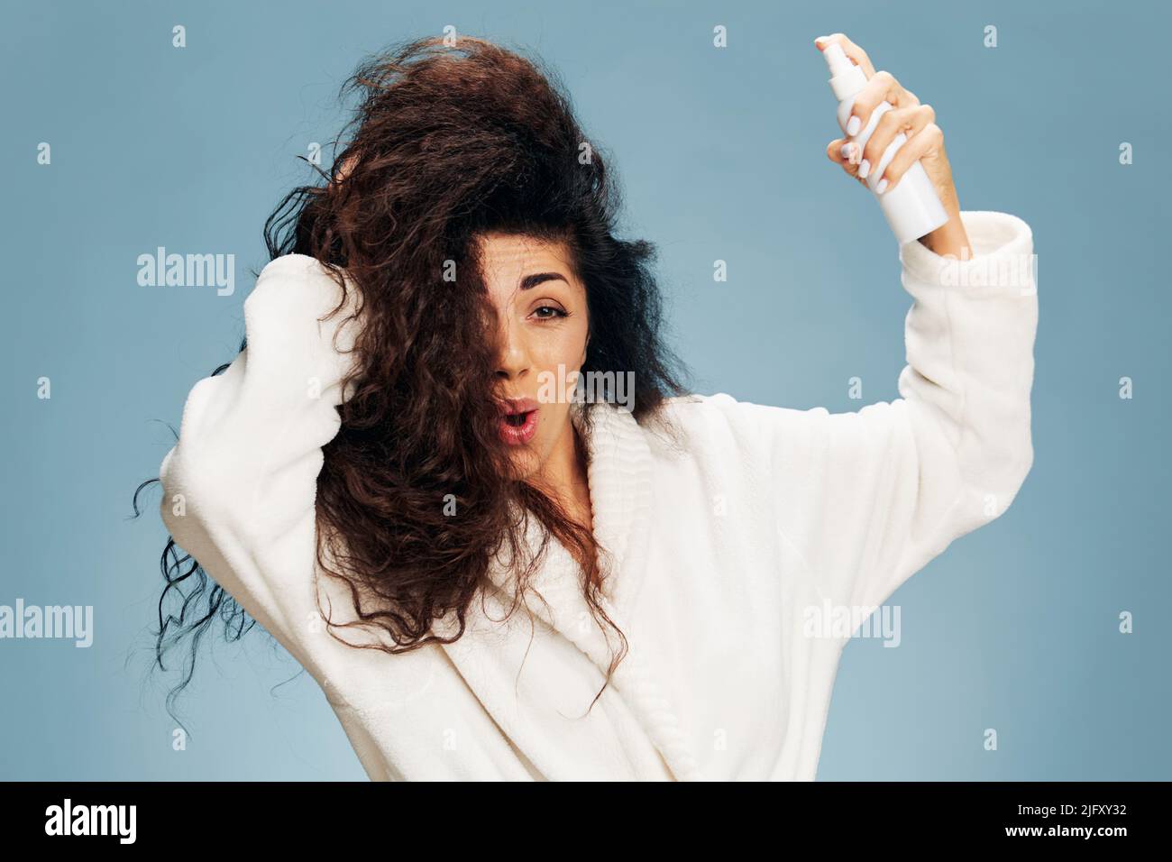 Hairstyling morning routine. Excited shocked tanned curly Latin lady in ...