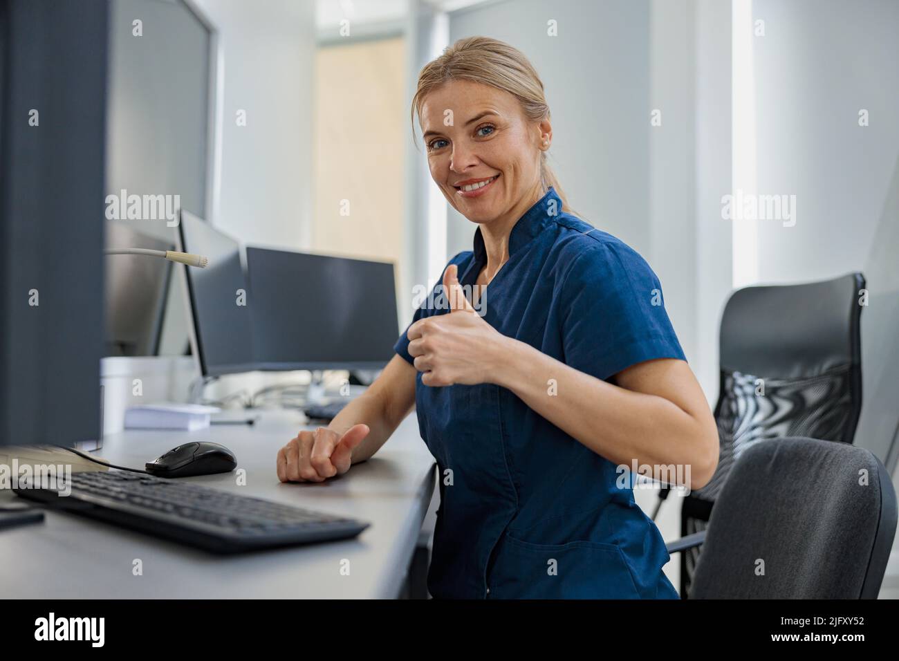 Nurse on Duty working on computer at the Reception Desk in modern ...