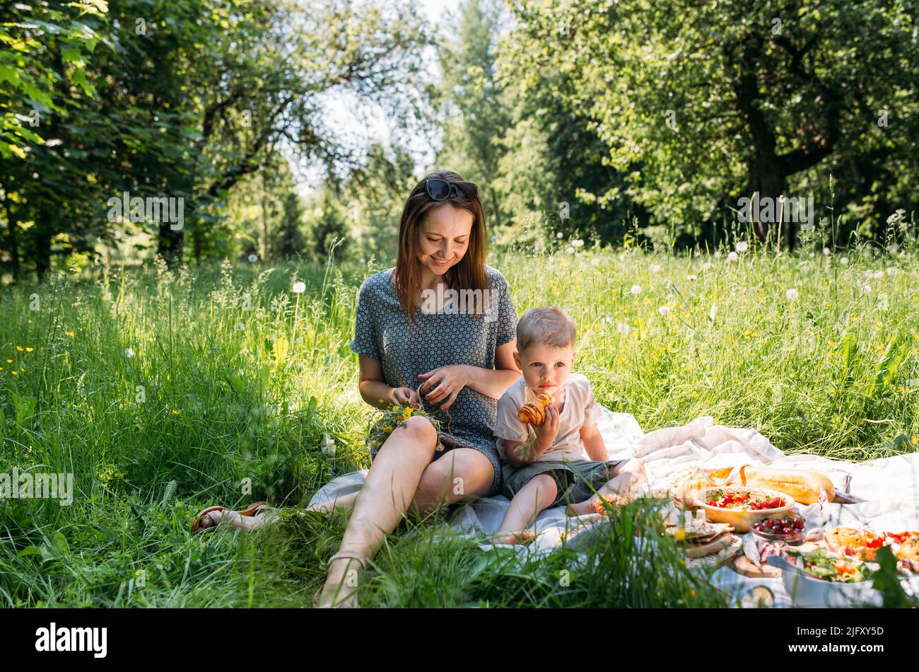 Family mom and son on picnic. Smiling and enjoying summer on blanket in ...